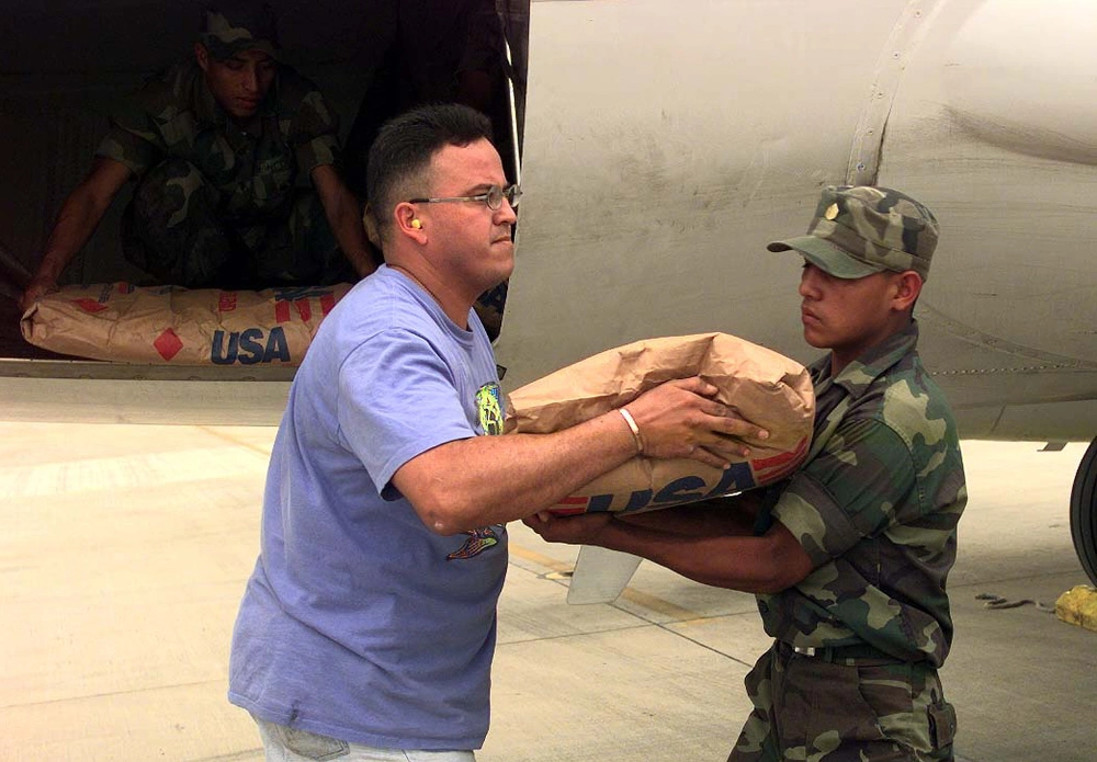 DVIDS - Images - U.S. Air Force Staff Sgt. Aguilar hands a 55-pound bag ...
